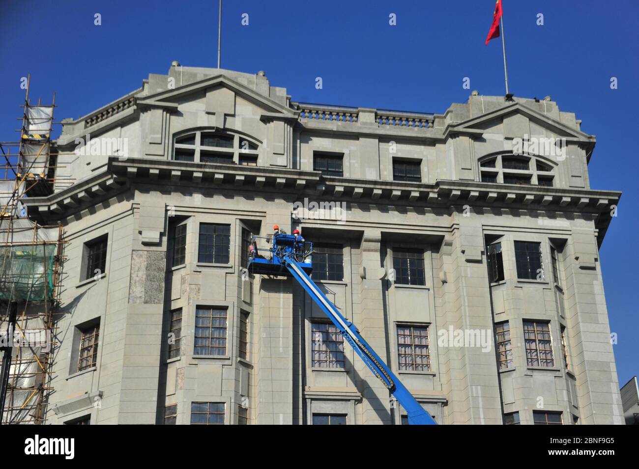 Workers are busy at renovating an old building, which belongs to the ...