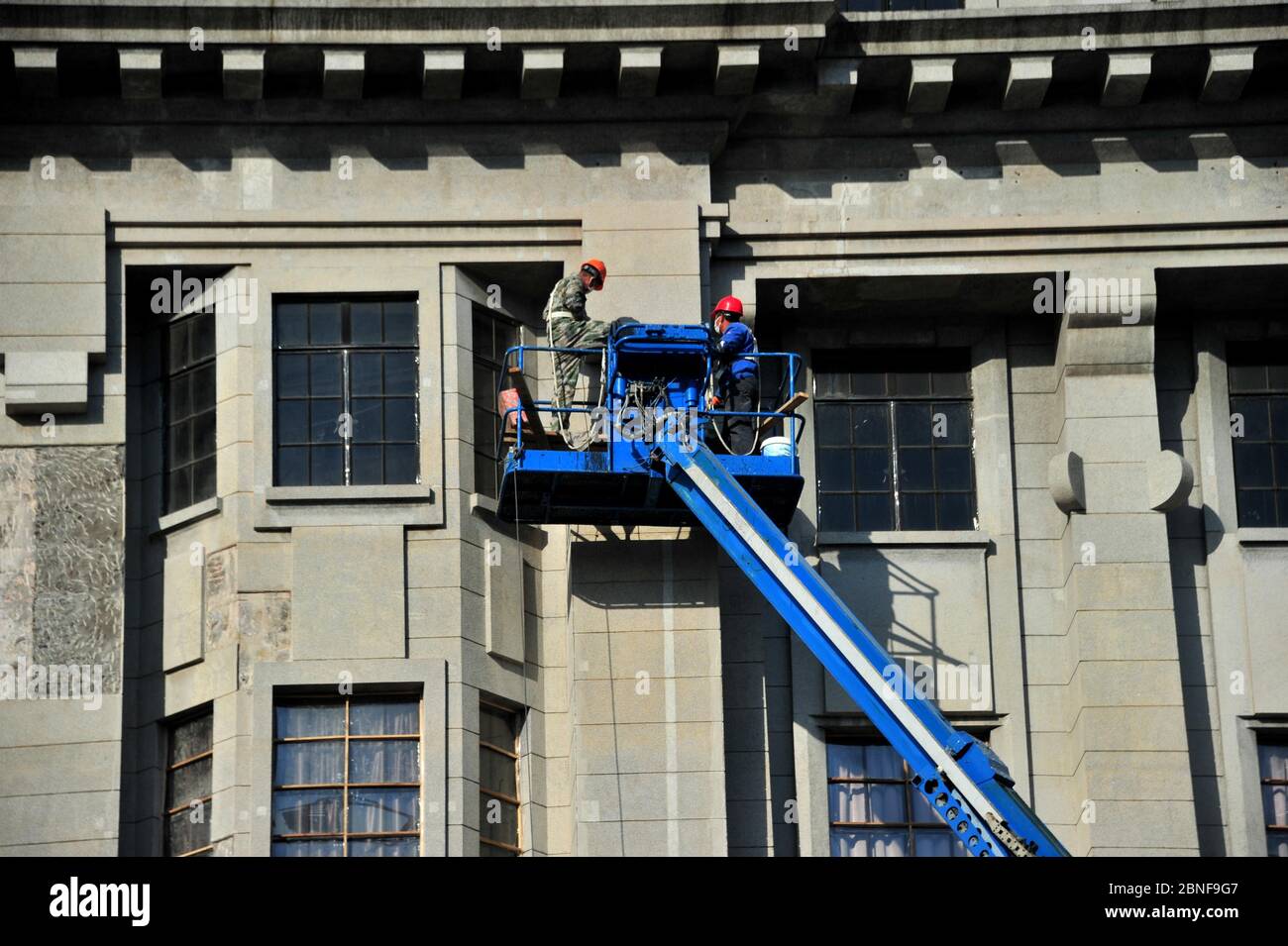 Workers are busy at renovating an old building, which belongs to the ...