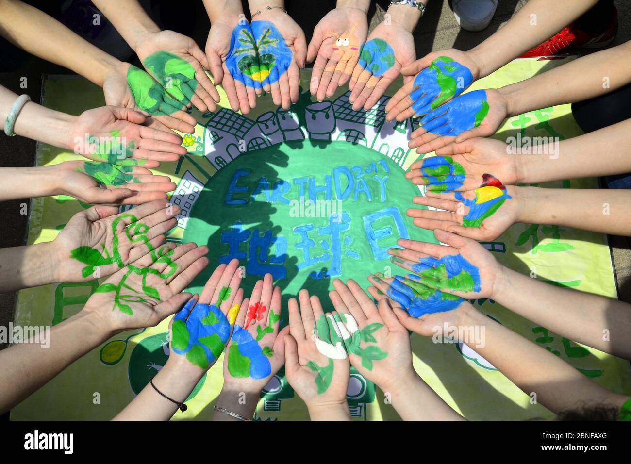 --FILE--A group of university students holds a globe with drawings ...