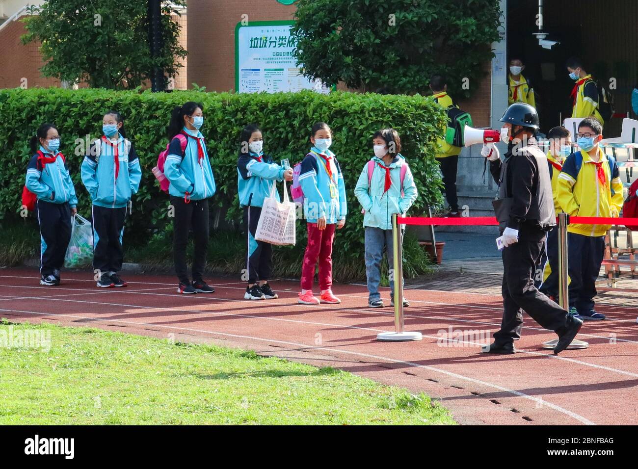 Students of a local primary school queue with a suitable distance ...