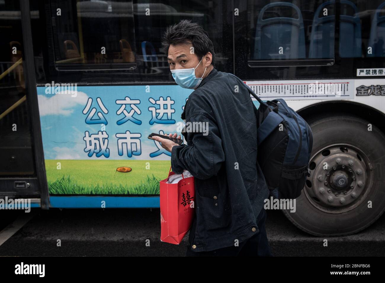 Passengers with face mask on prepare to take buses to their destination ...
