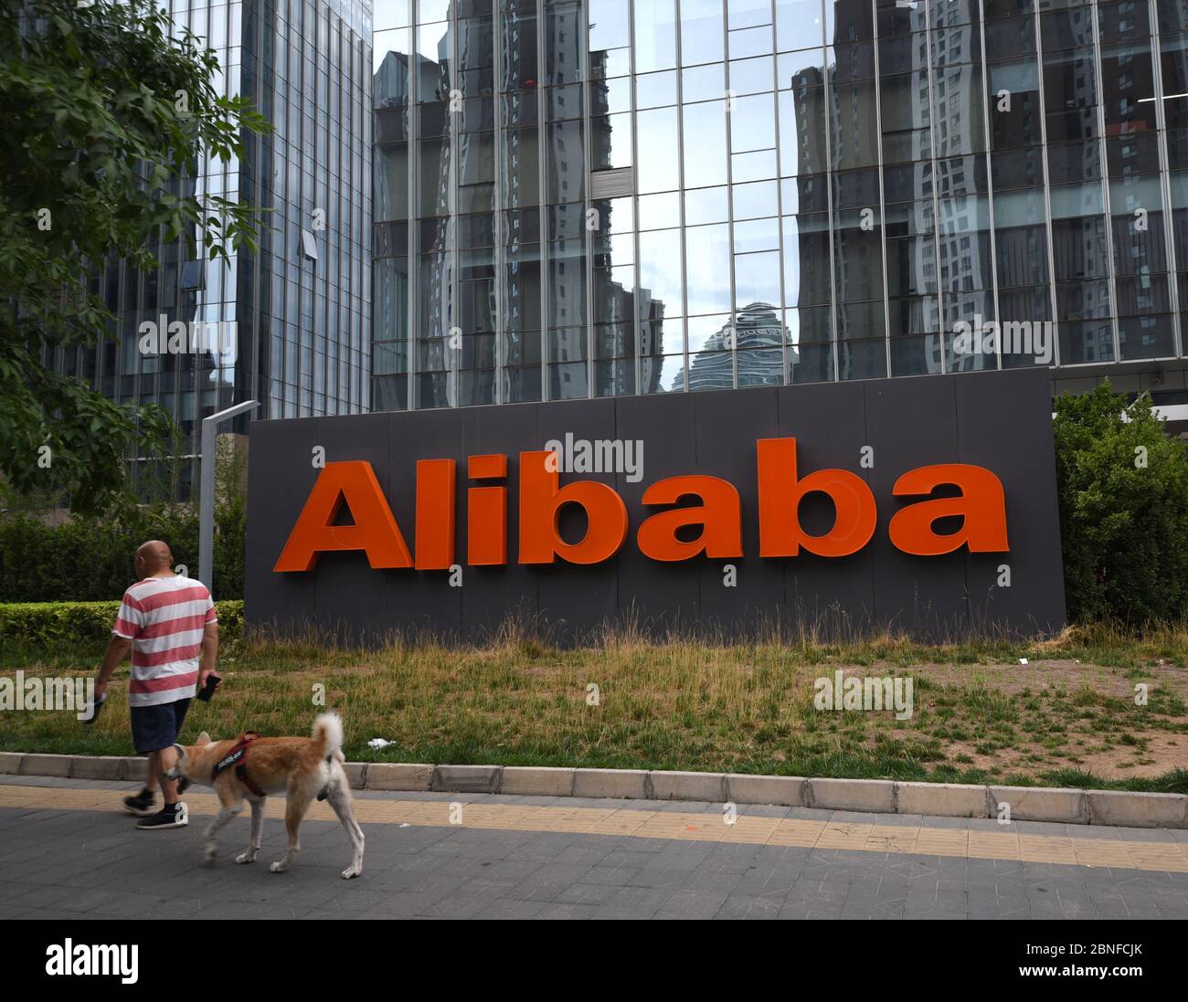 --FILE--A pedestrian walks past Alibaba headquarters in Beijing, China ...