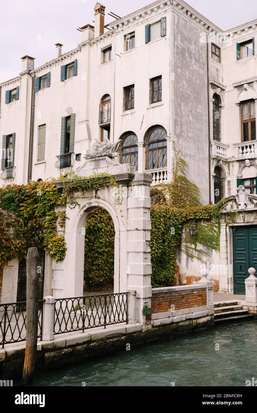 Beautiful stone arched entrance to the building, a green door and ...