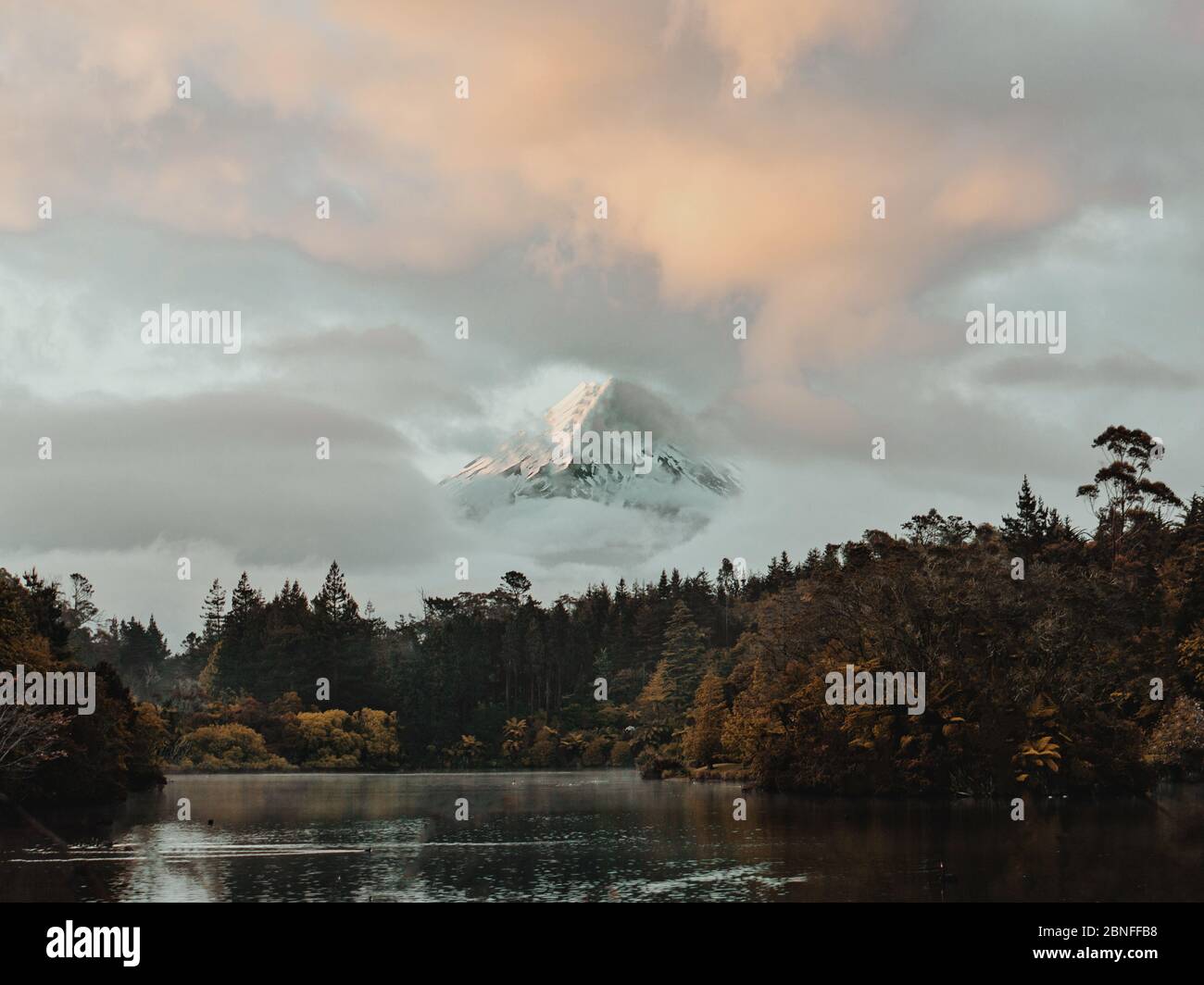 Magnificent snow-covered mountain peak visible through the fog over a ...