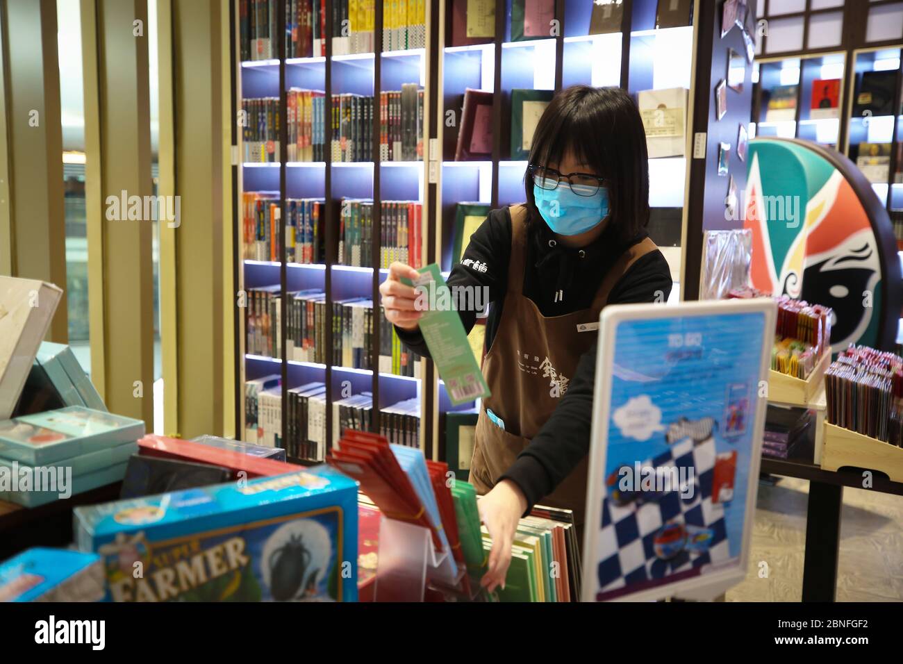 A bookstore staff arranges books on the shelves in Zhongshuge Bookstore ...