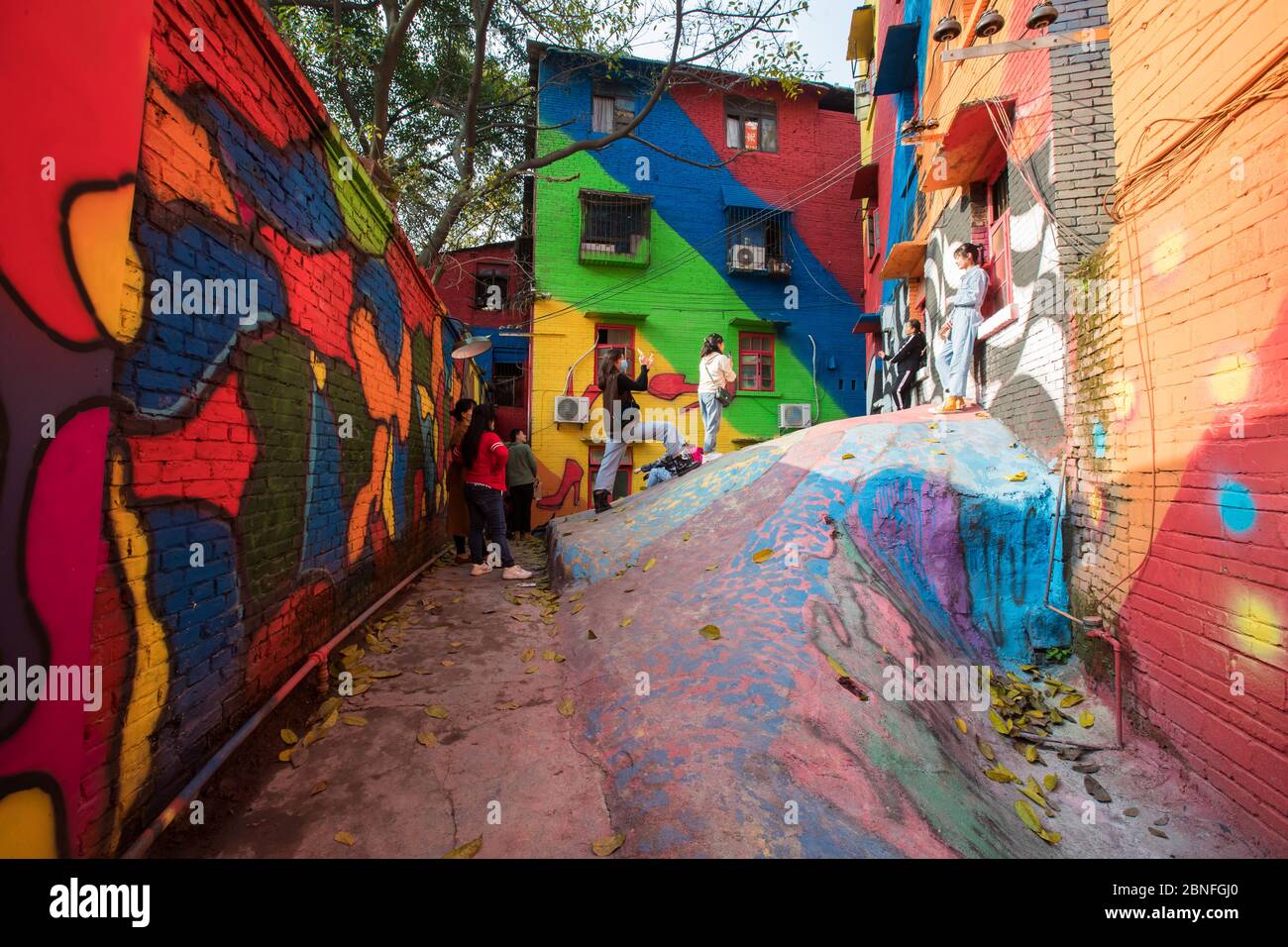 People take pictures against the colorful houses in Qicai Xiang, an old ...