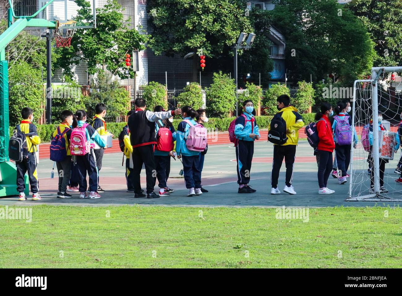 Students of a local primary school queue with a suitable distance ...