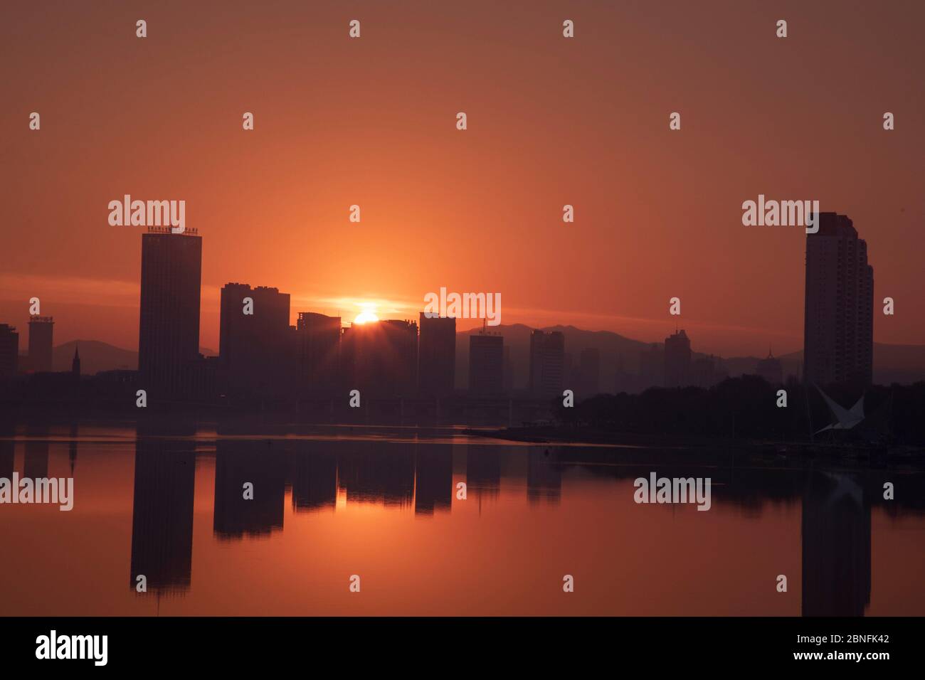 Outline of local skyscrapers across the Songhua River are seen with ...