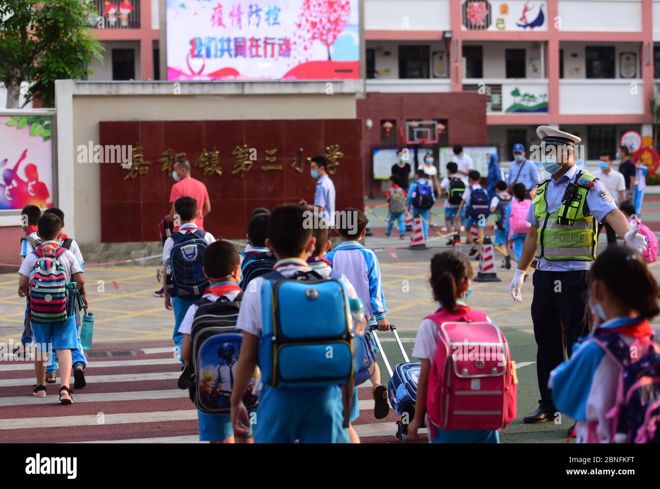 Students queue with a suitable distance under the guidance of a ...
