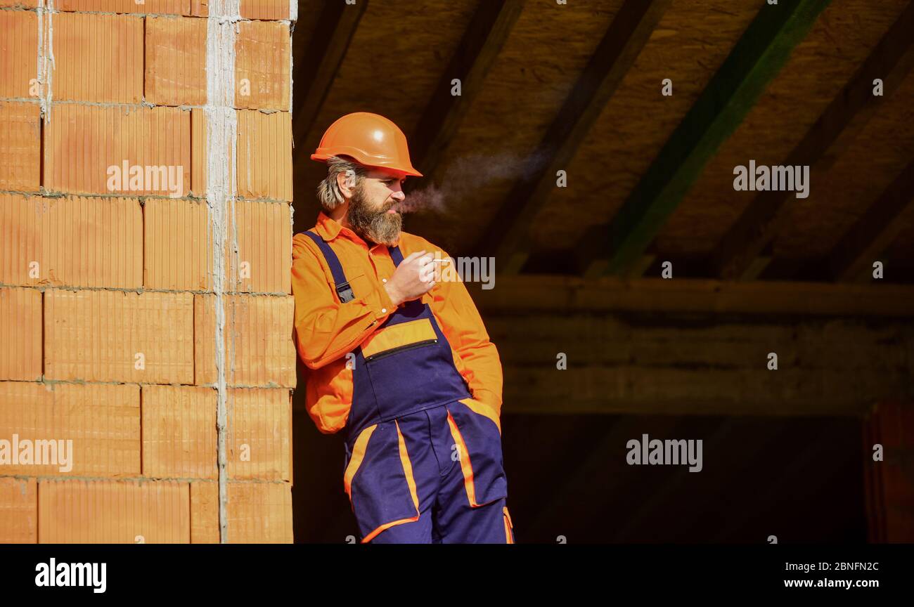 construction worker smoking cigarette. building is under construction ...