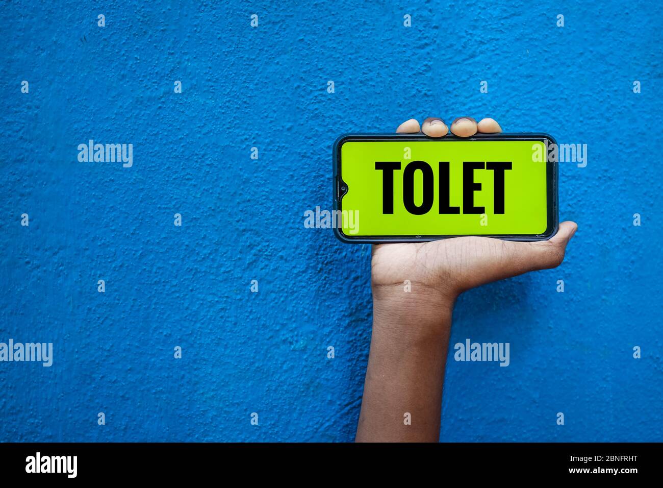 Tolet wording on smart phone screen isolated on blue background with ...