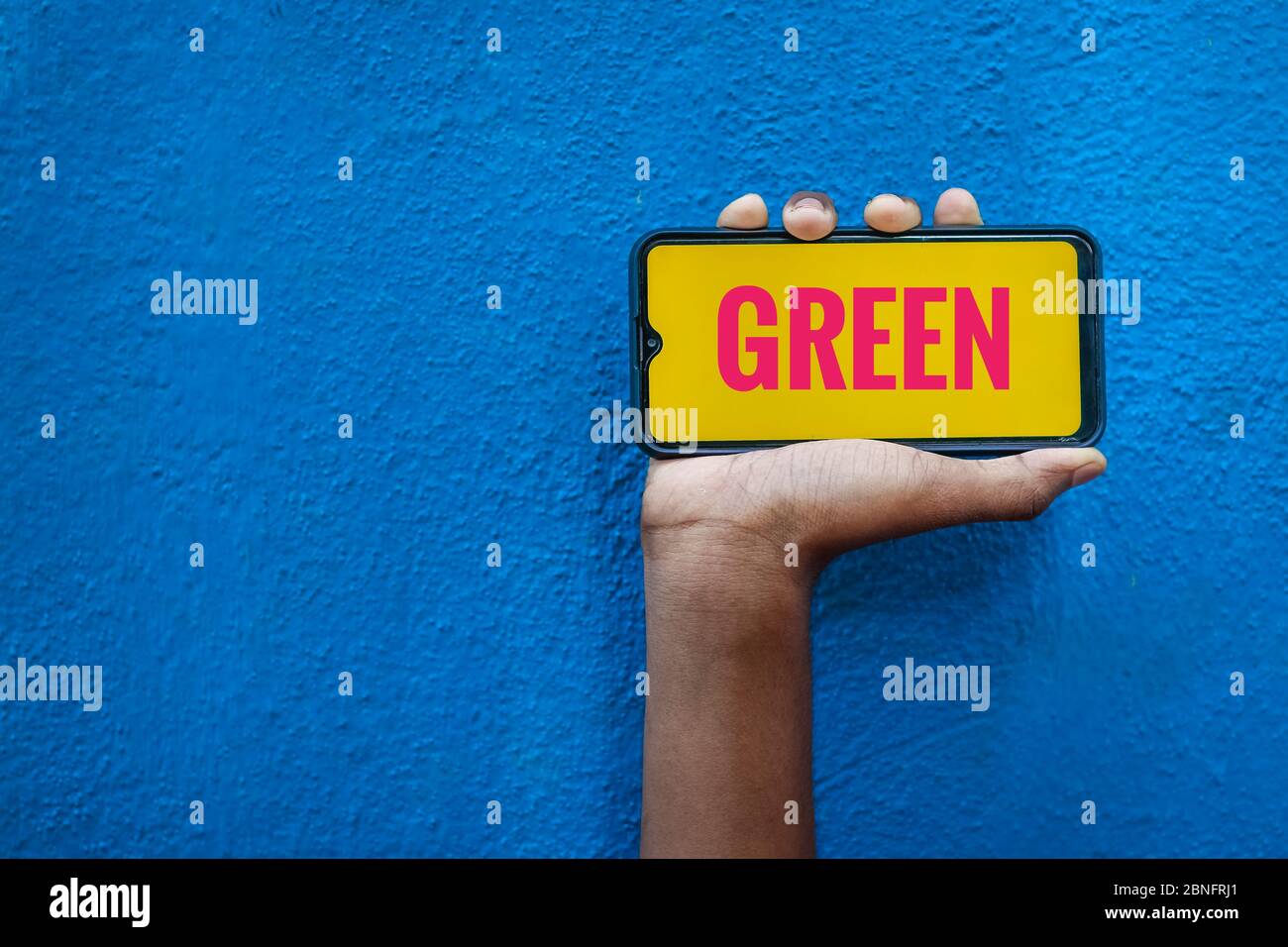green word on red color in smart phone screen isolated on blue ...