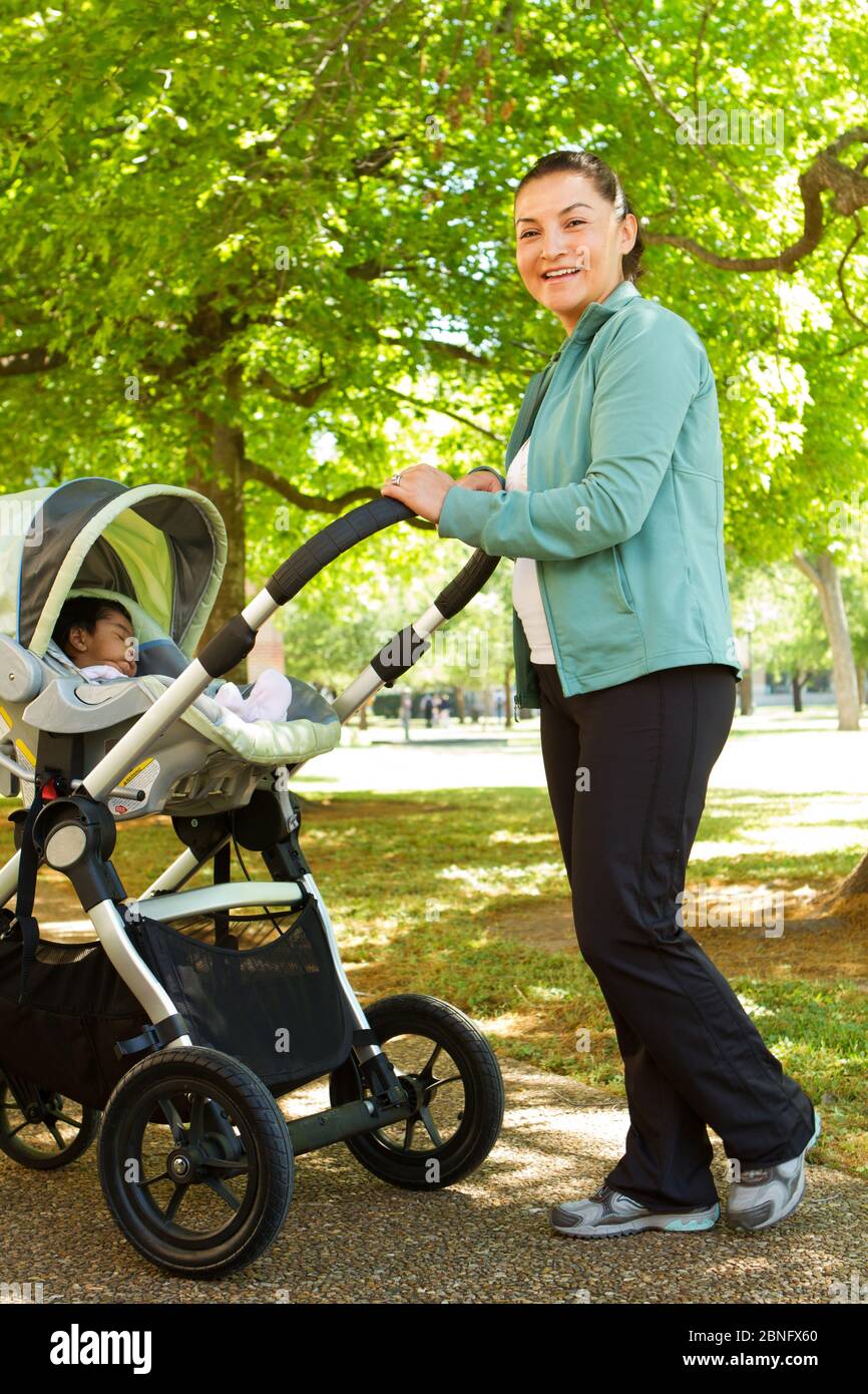 Mom pushing her baby in a stroller Stock Photo - Alamy