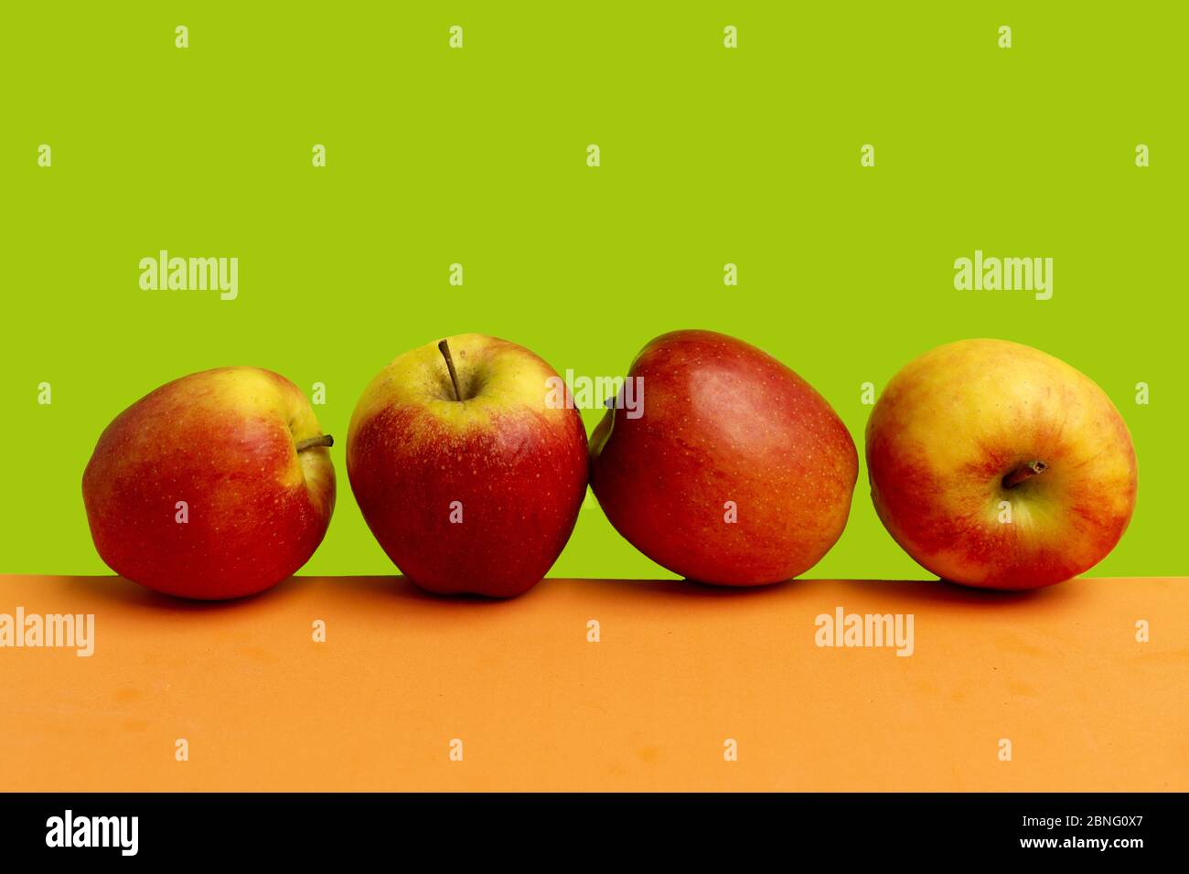 Fresh yellow and red apples isolated on a green background Stock Photo ...