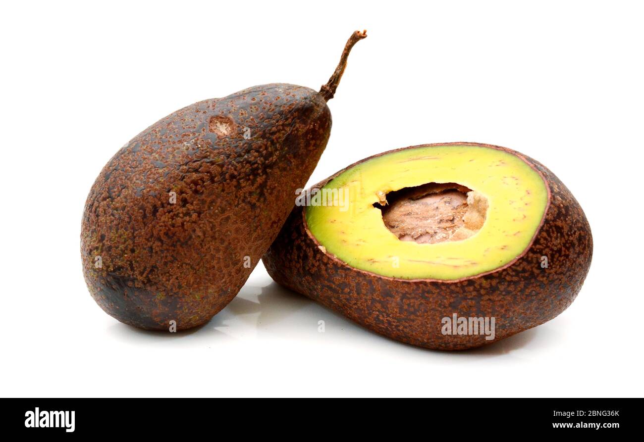 Fresh Avocados two whole and one halved isolated on white Stock Photo ...