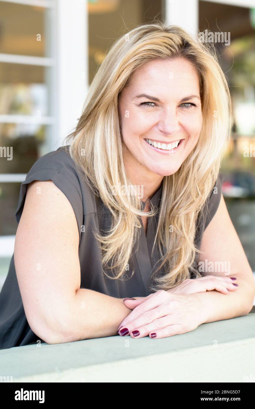 Portrait of a confident woman smiling outside Stock Photo - Alamy