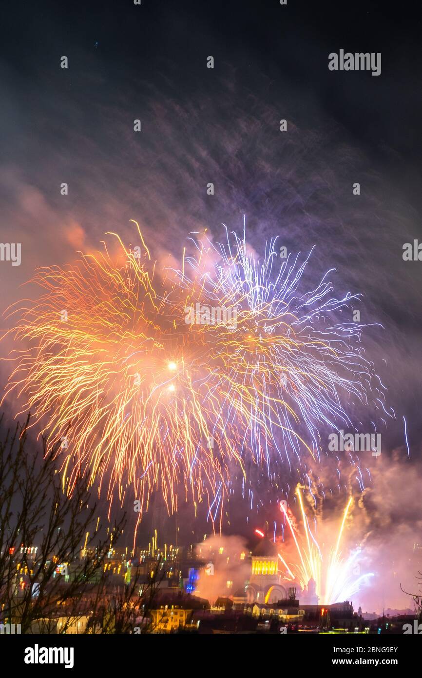 Vertical shot of the colorful fireworks over a city in the night sky ...