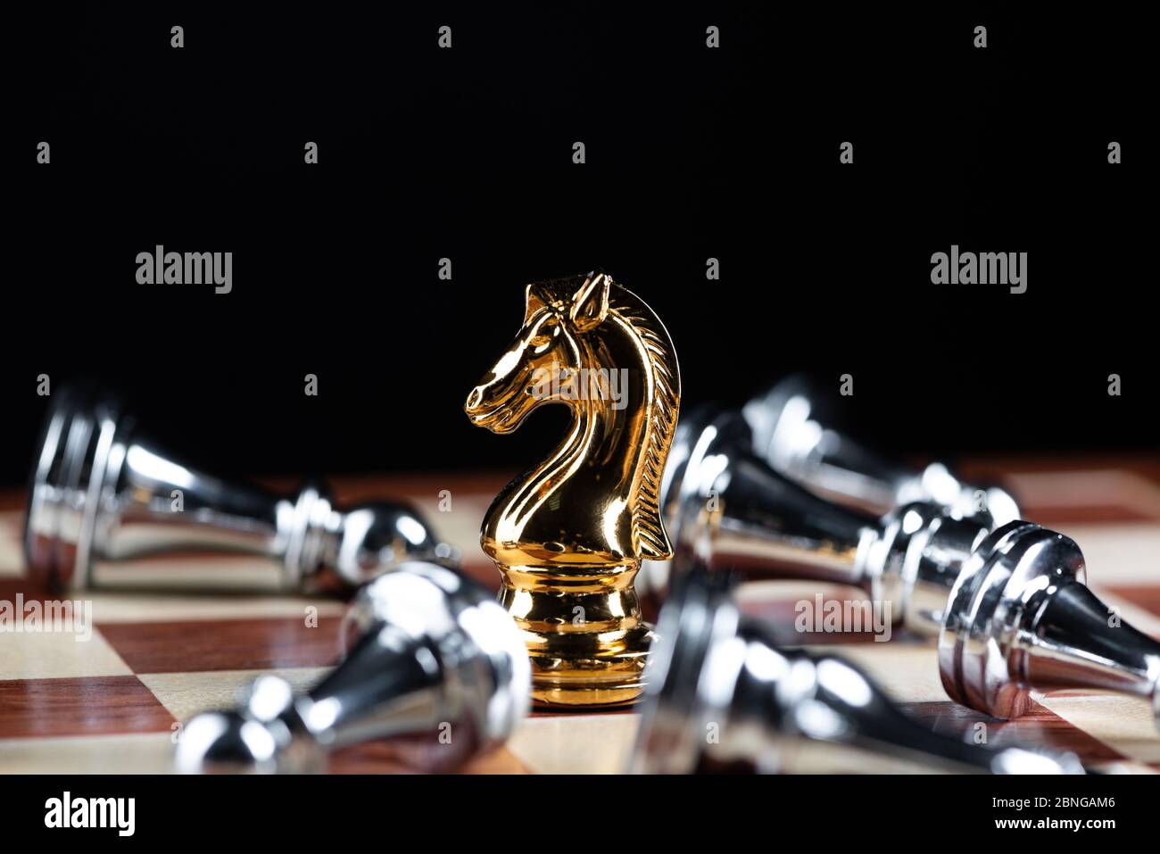 Gold knight chess defeats silver figures on board Stock Photo - Alamy