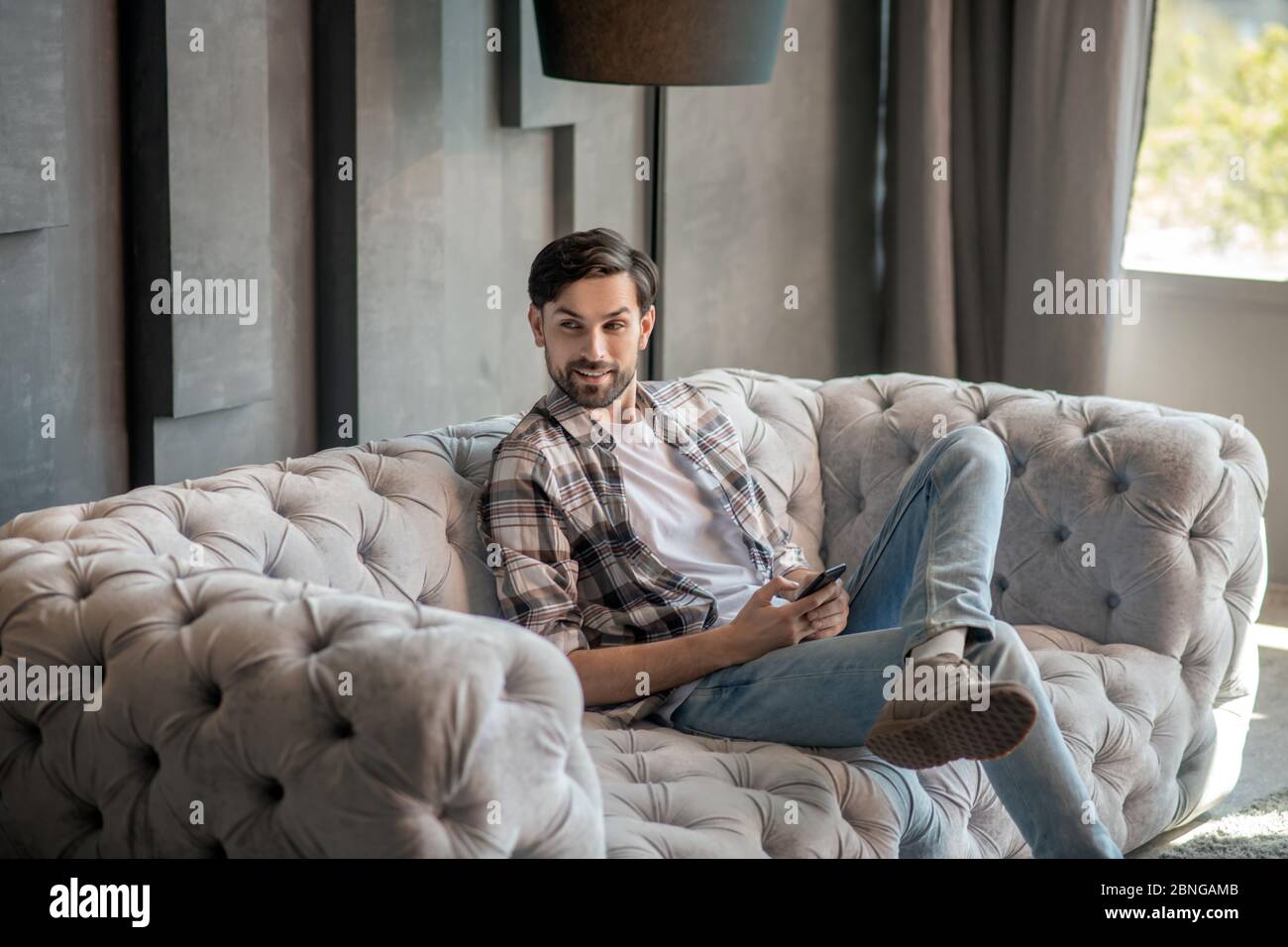 Successful man sitting at home on the couch Stock Photo - Alamy