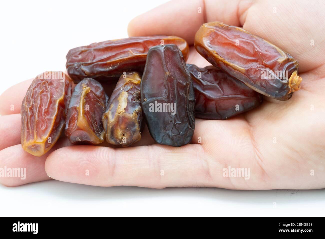 Hand holding pitted dates isolated on white background Stock Photo - Alamy