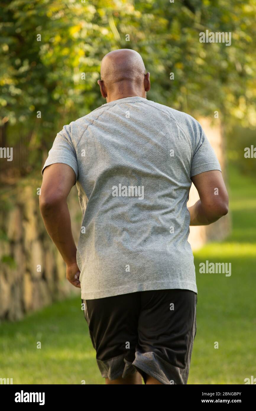 Mature fit African American man running outside Stock Photo - Alamy