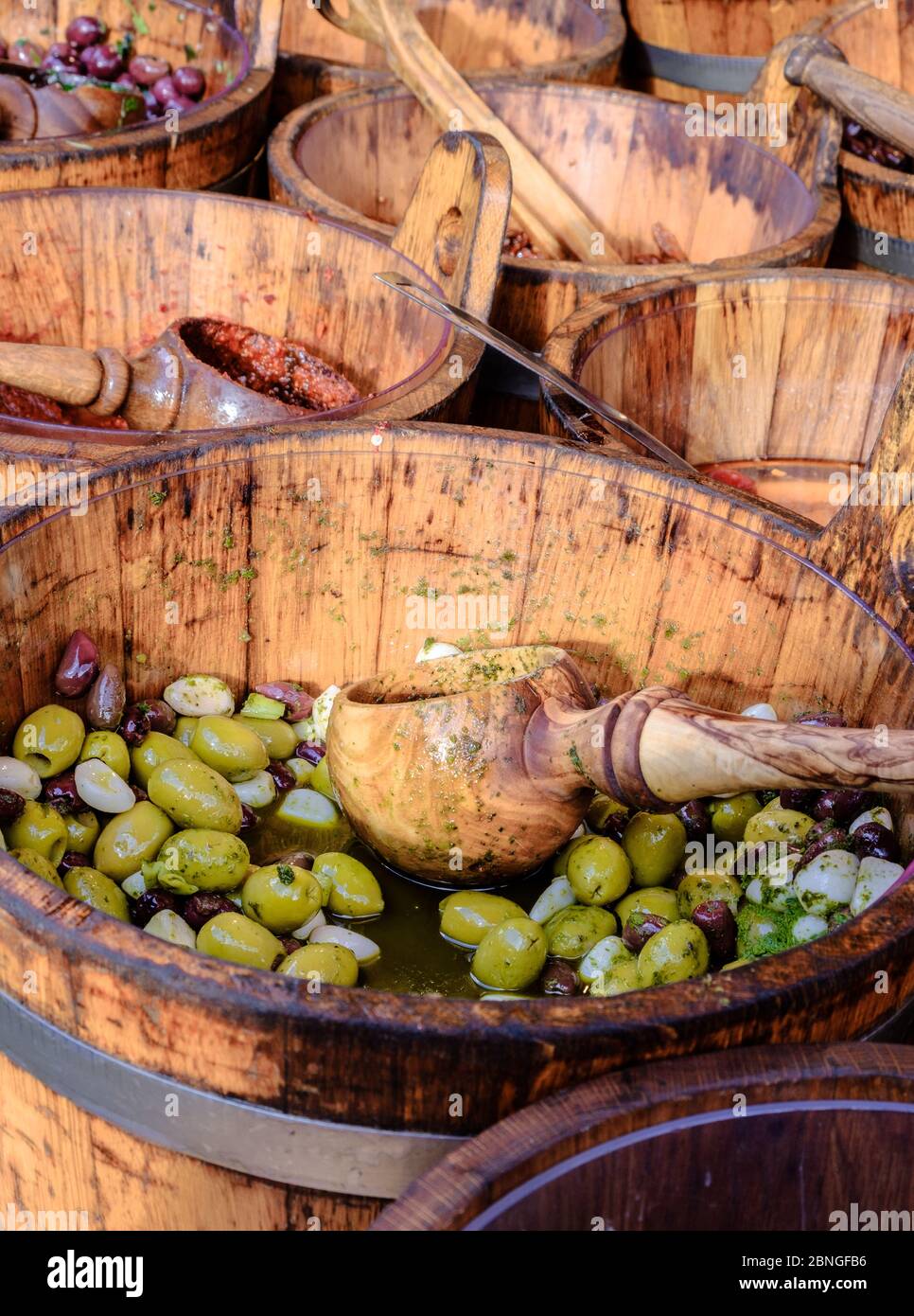 Close up of wooden vats of fresh olives with wooden scoops for sale at ...