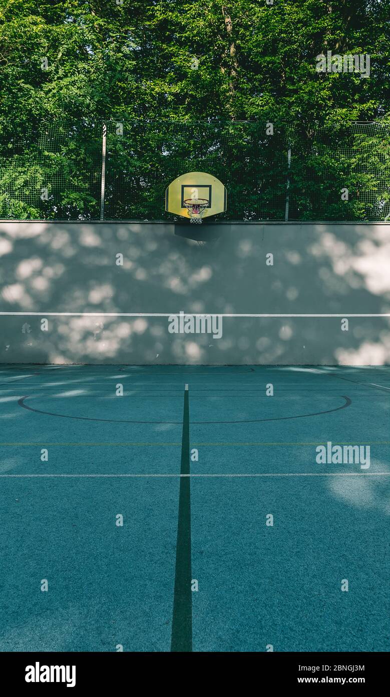 Outdoor basketball field with blue ground and trees Stock Photo - Alamy