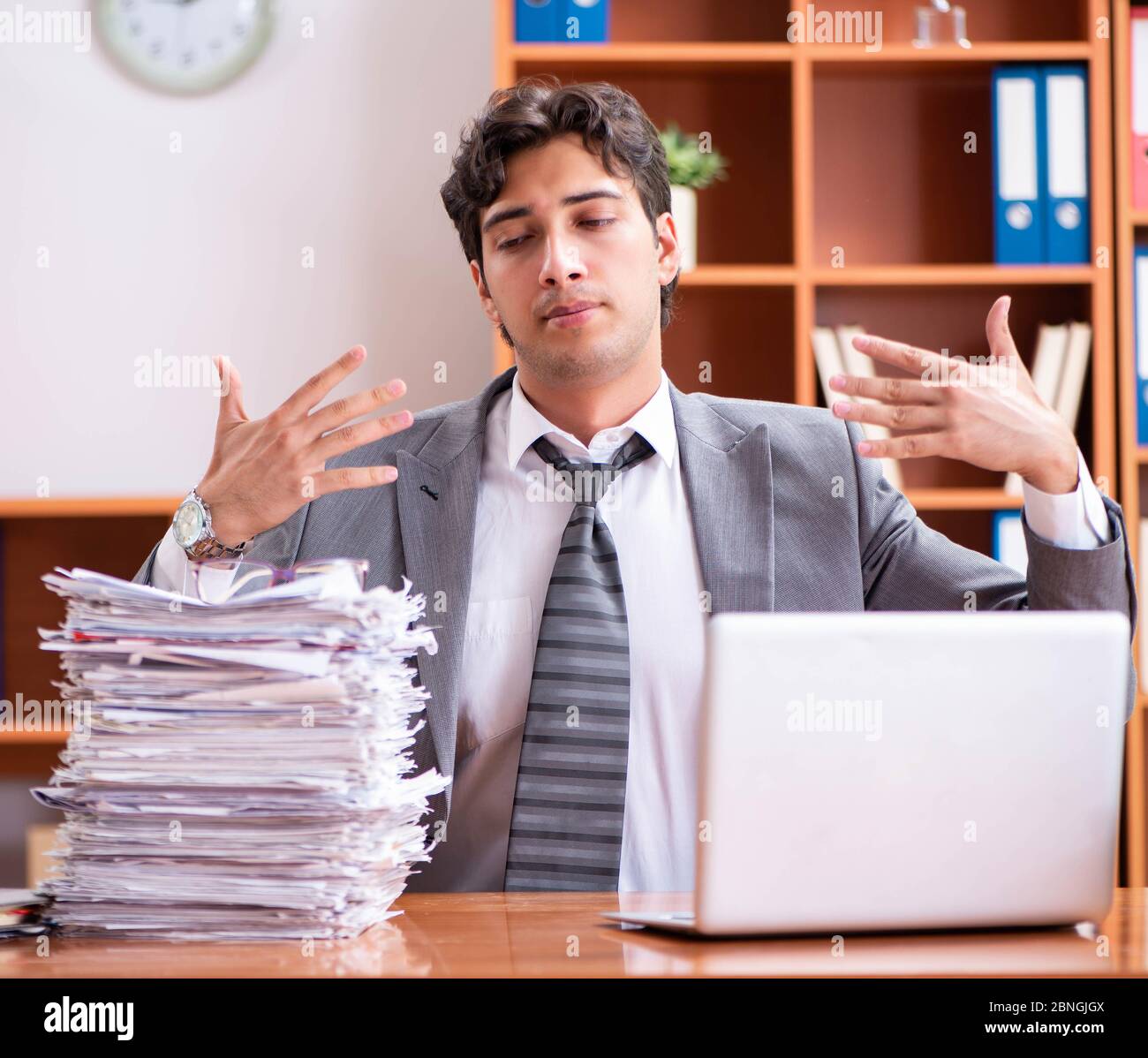 The young handsome businessman unhappy with excessive work Stock Photo ...
