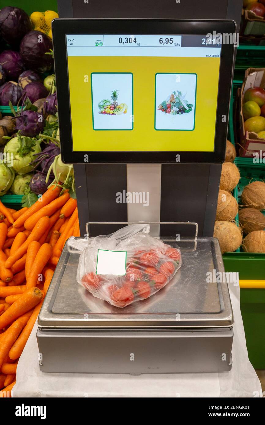 weighing of vegetable on electronic scales in supermarket Stock Photo ...