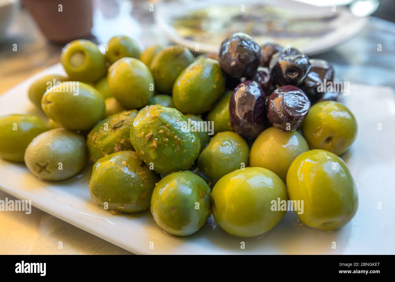 Spiced olives in a small plate on the tapas bar table a typical Spanish ...