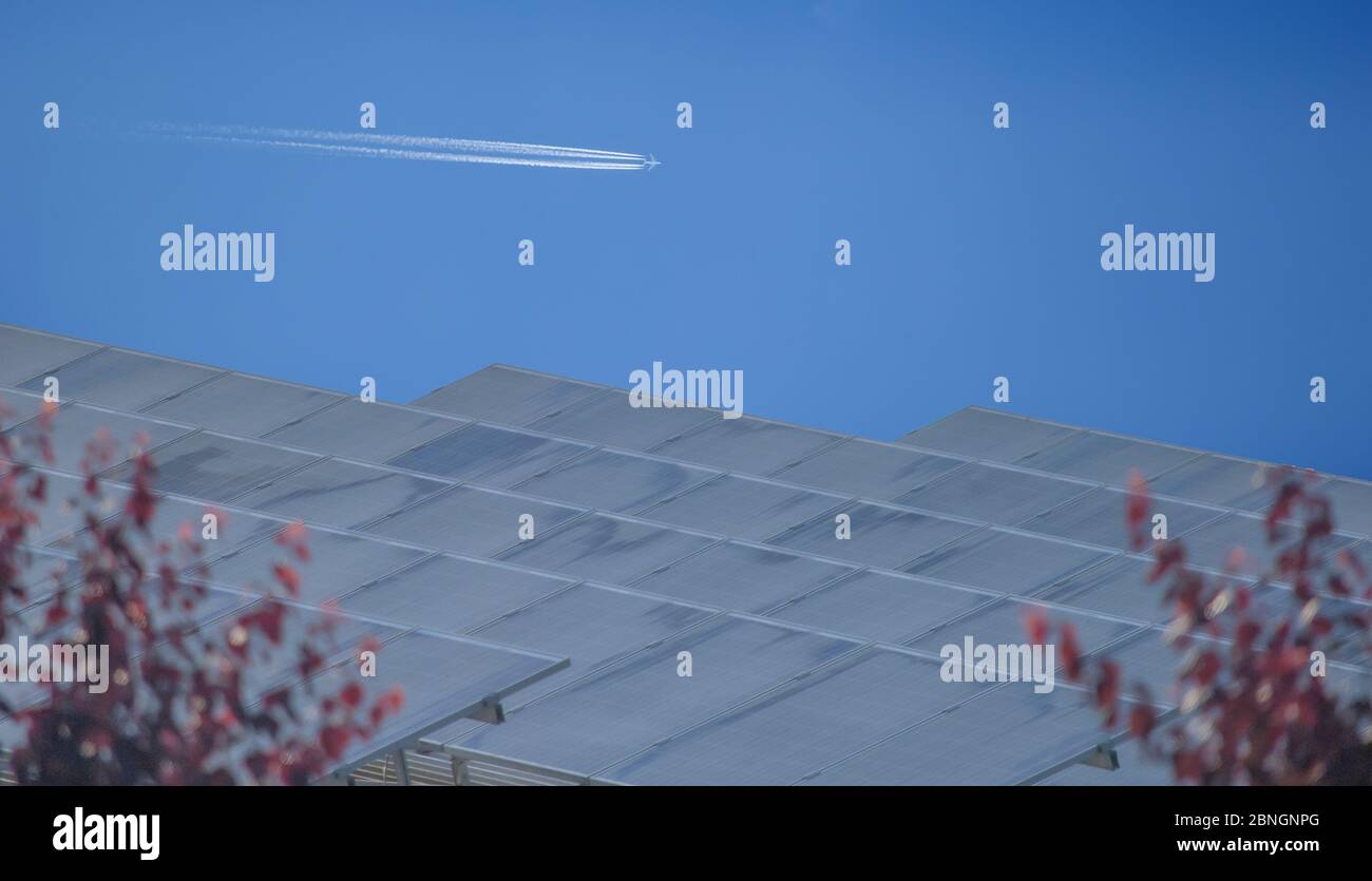 Airplane flying over the solar panels in the blue sky Stock Photo - Alamy