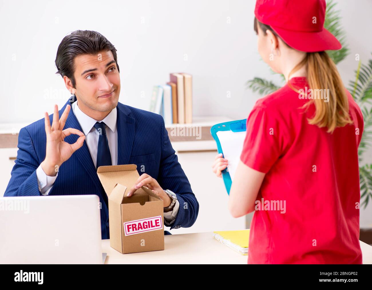The courier delivering parcel to the office Stock Photo - Alamy