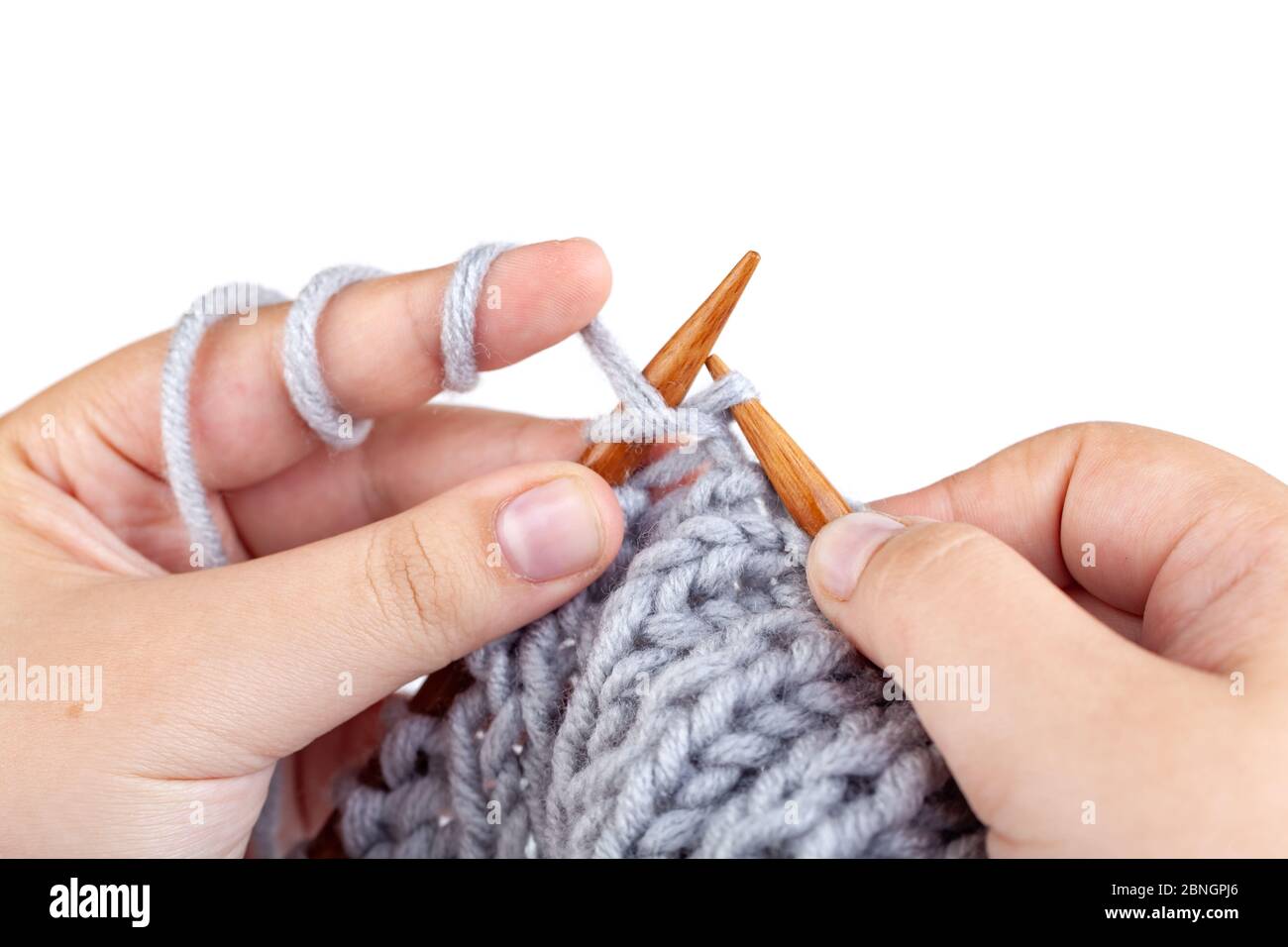Women's hands knit from grey wool on white background. Hand knitting ...