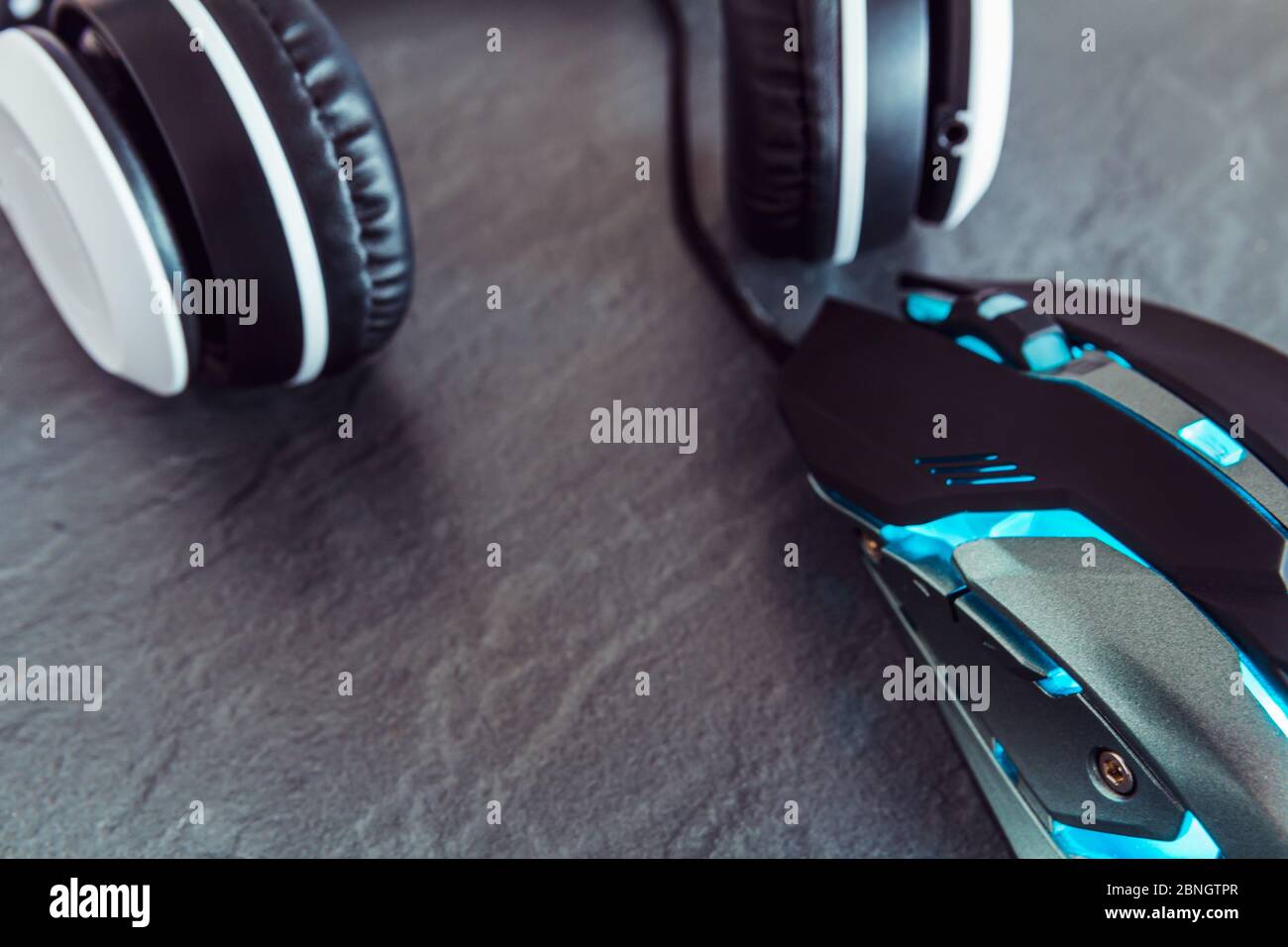 Blue gaming mouse with white headphones on stone texture table Stock ...