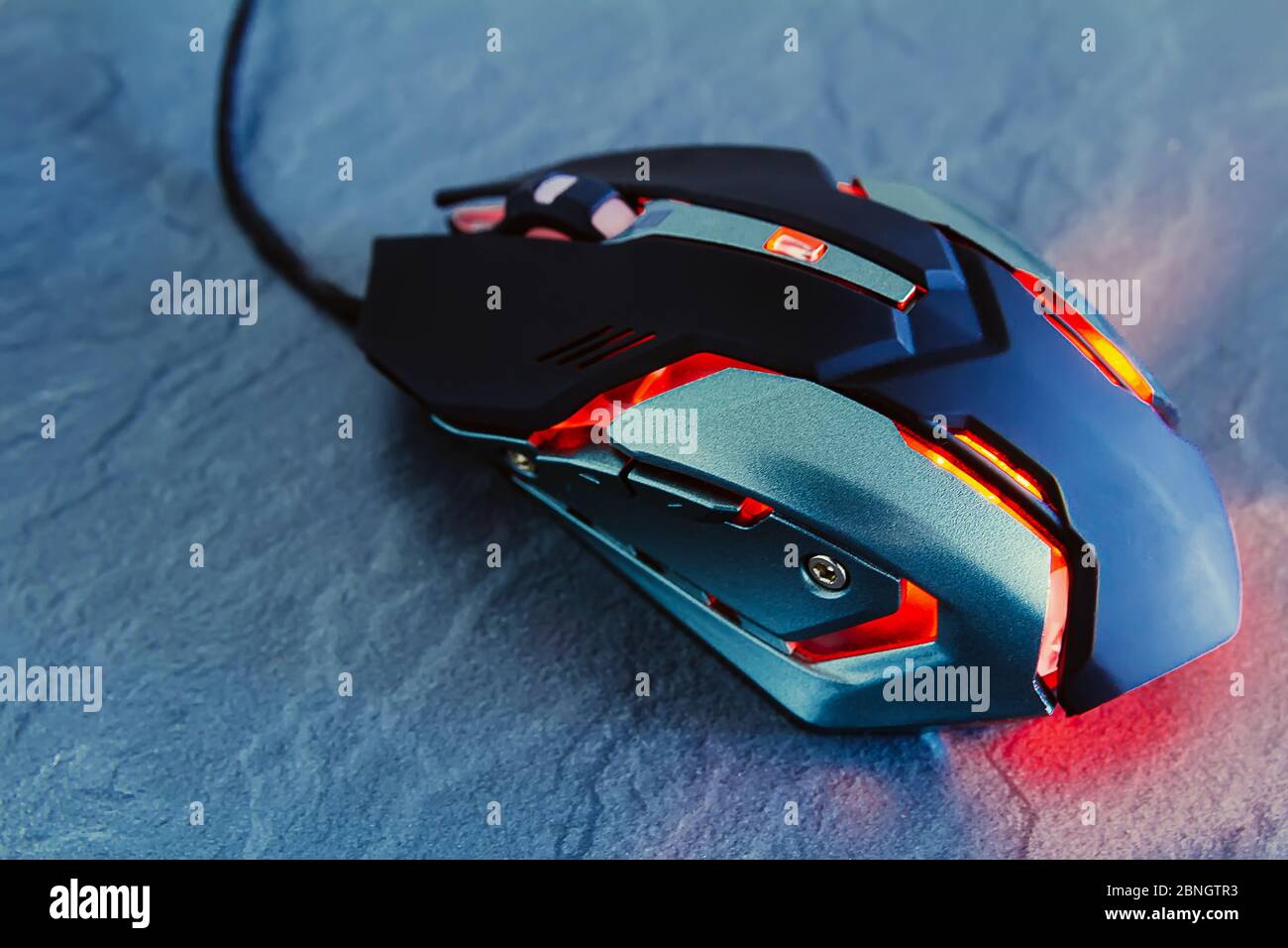Red gaming mouse on stone texture table Stock Photo - Alamy