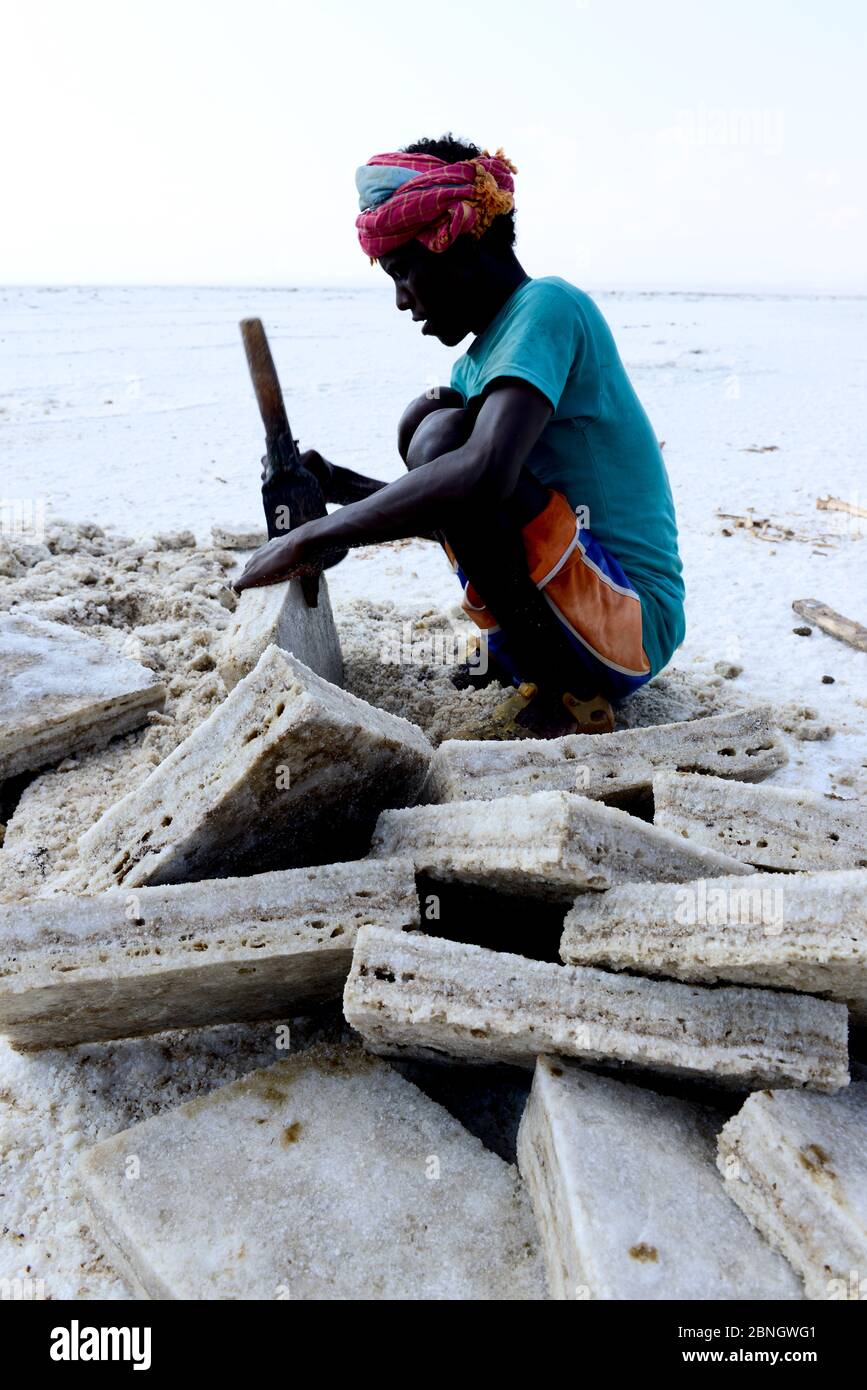 Salt extraction at Lake Assale on the Danakil depression, Afar man cuts ...