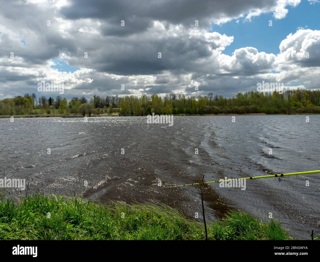 spring landscape with a lake, fisherman's fishing on the lake shore ...