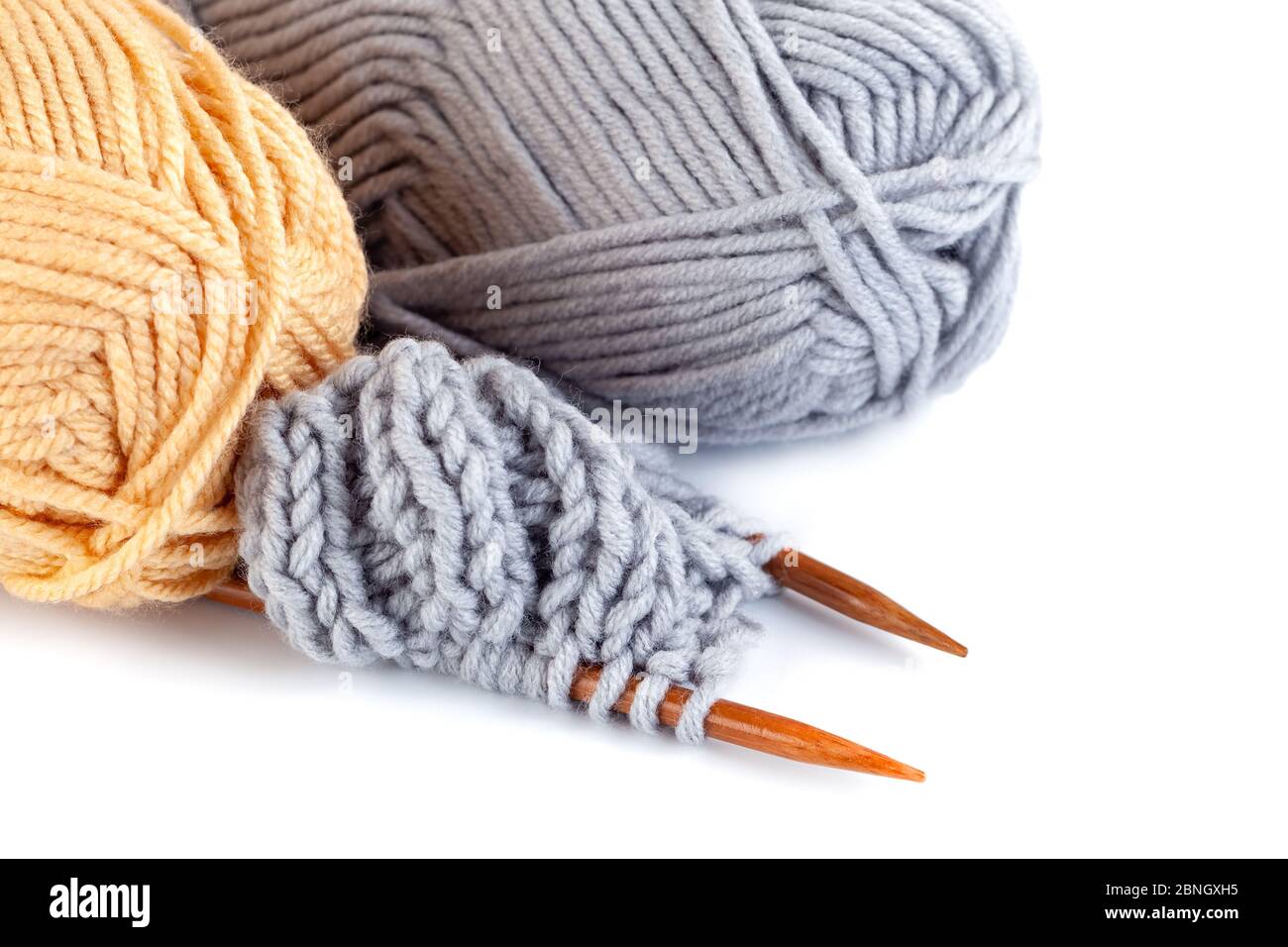 knitting needles and grey and yellow woolen threads isolated on white ...