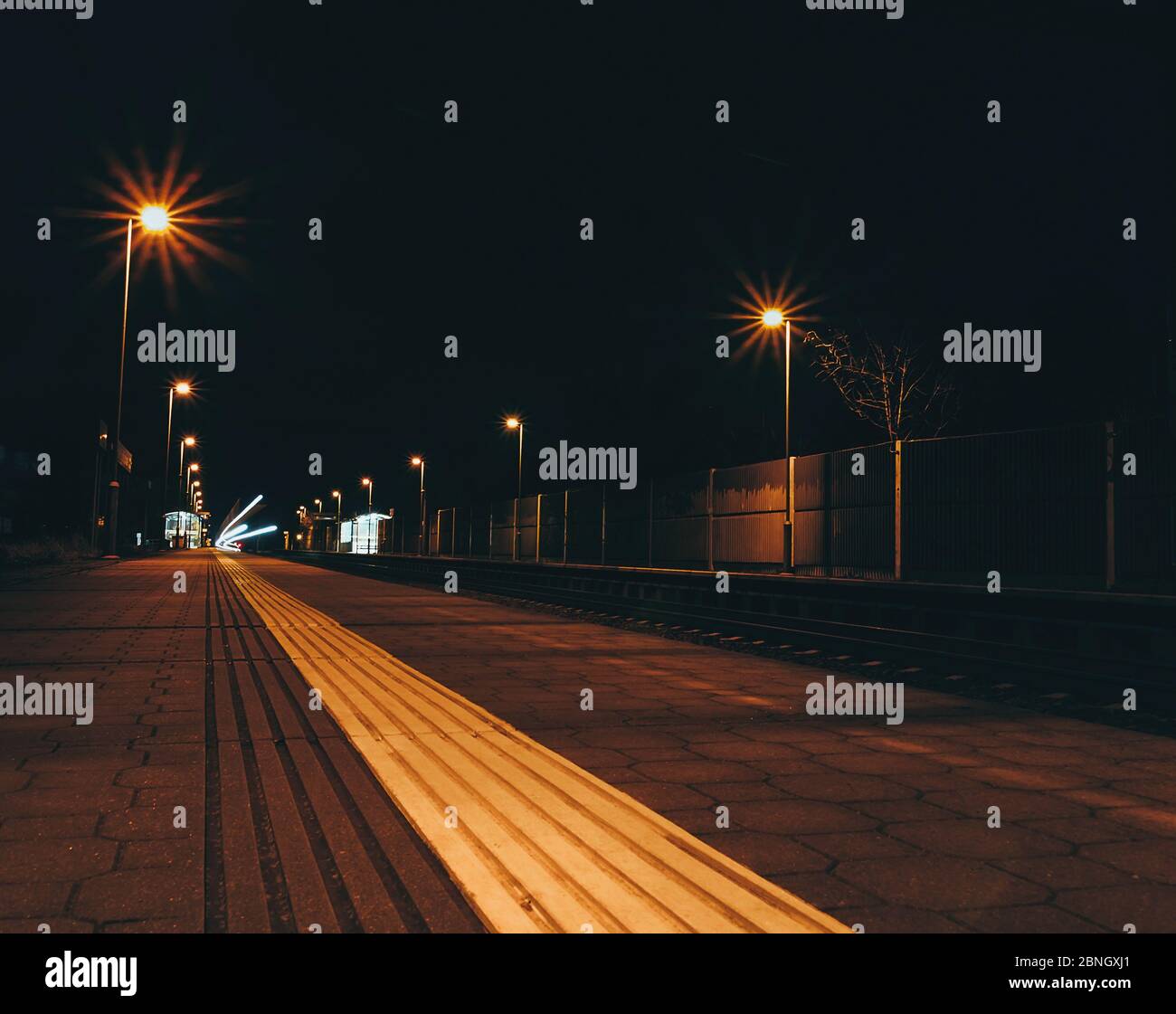 Light colorful train trails at night. Train stop in station. Traffic ...