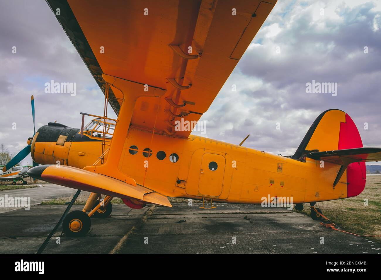 Yellow biplane from side standing on airports with cloud sky Stock ...