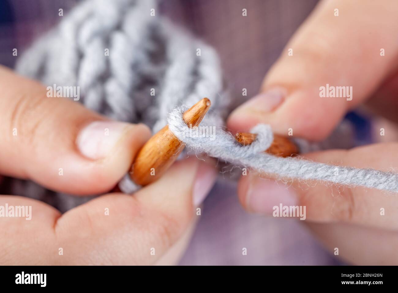 Women's hands knit from grey wool. Hand knitting Stock Photo - Alamy