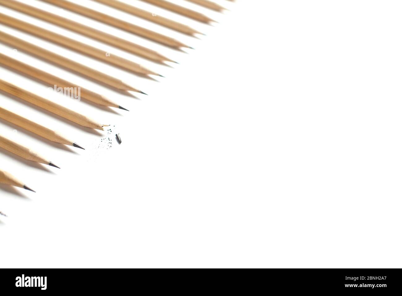 Side view of row of even beautiful sharpened pencils lying on white ...