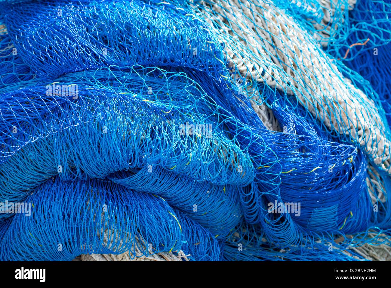 Overhead view of blue fishing nets lying in the sunshine filling the ...