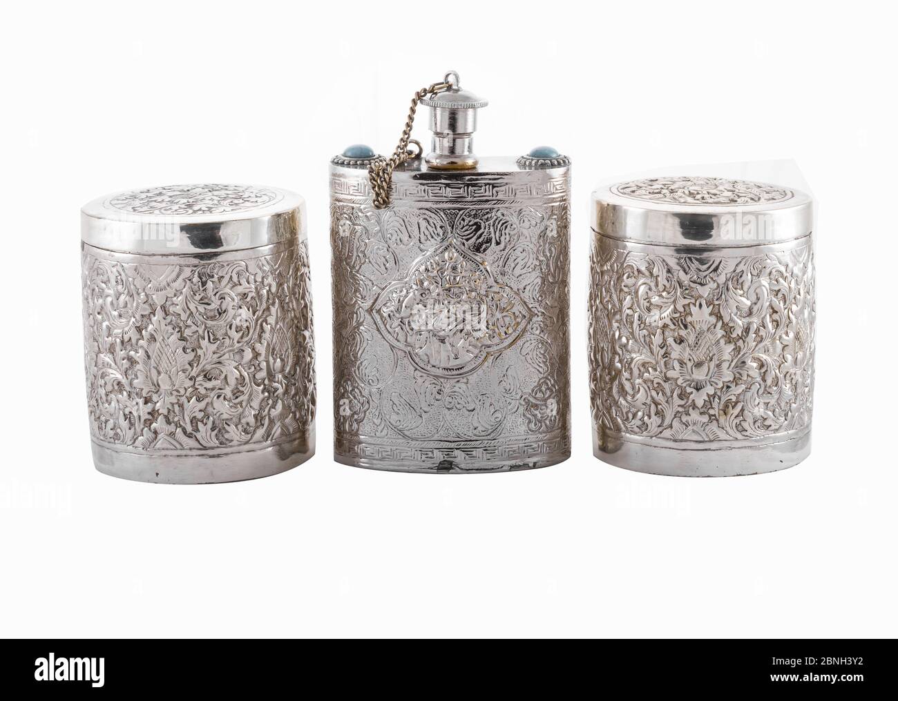 Closeup of a silver vintage hip flask and two containers isolated on a ...