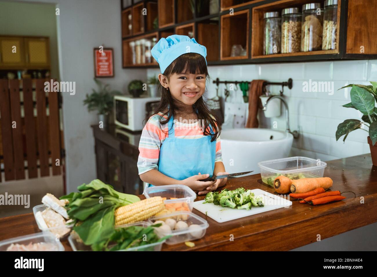 asian kid with apron cooking in the kitchen Stock Photo - Alamy