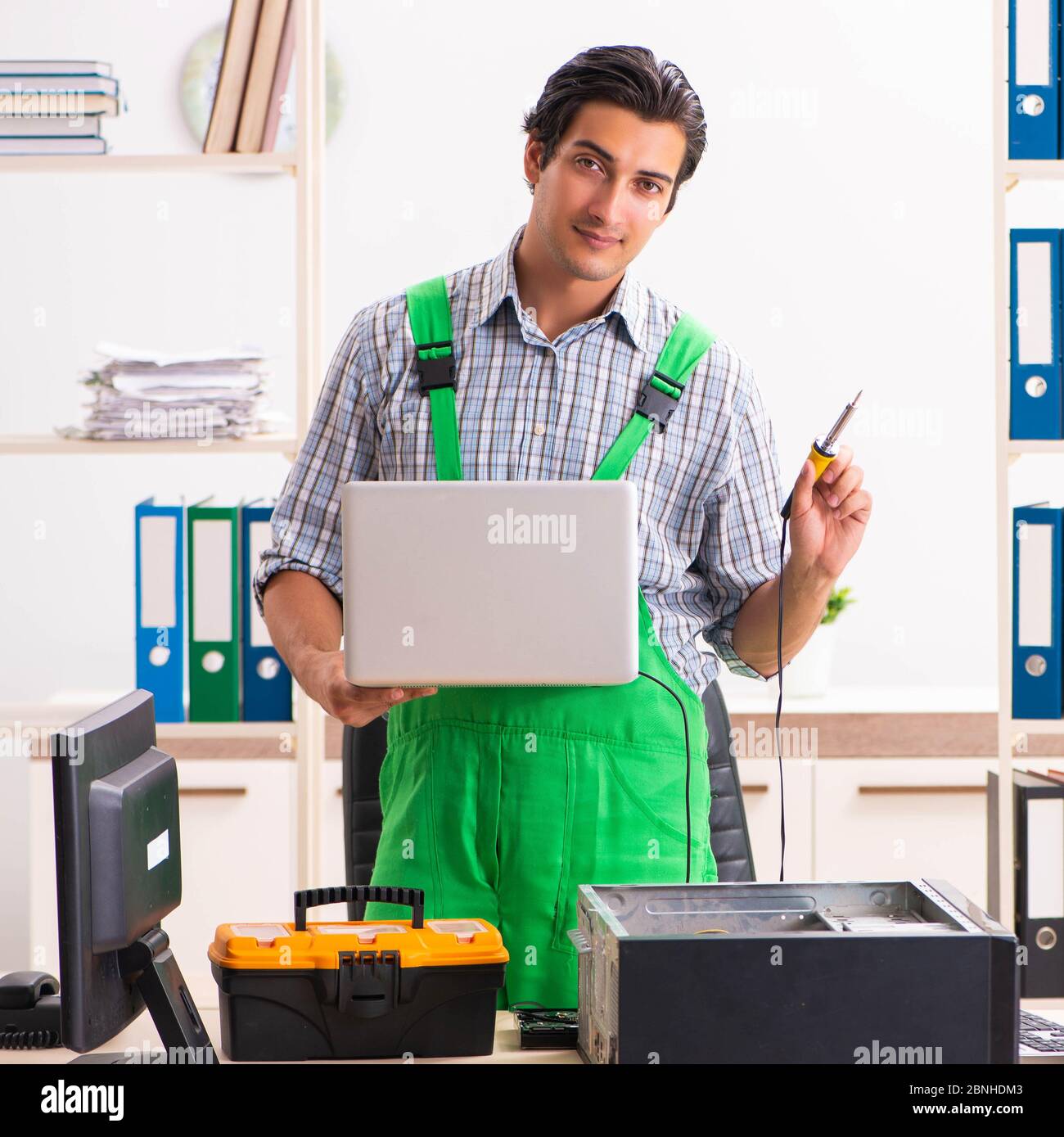 The young engineer repairing broken computer at the office Stock Photo ...