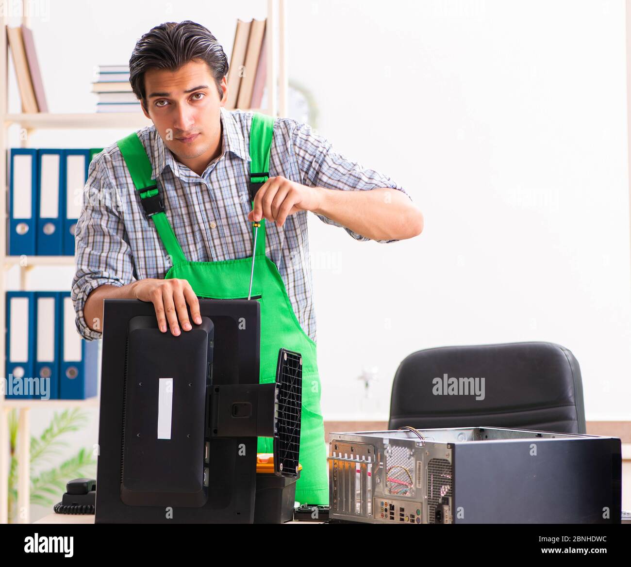 The young engineer repairing broken computer at the office Stock Photo ...