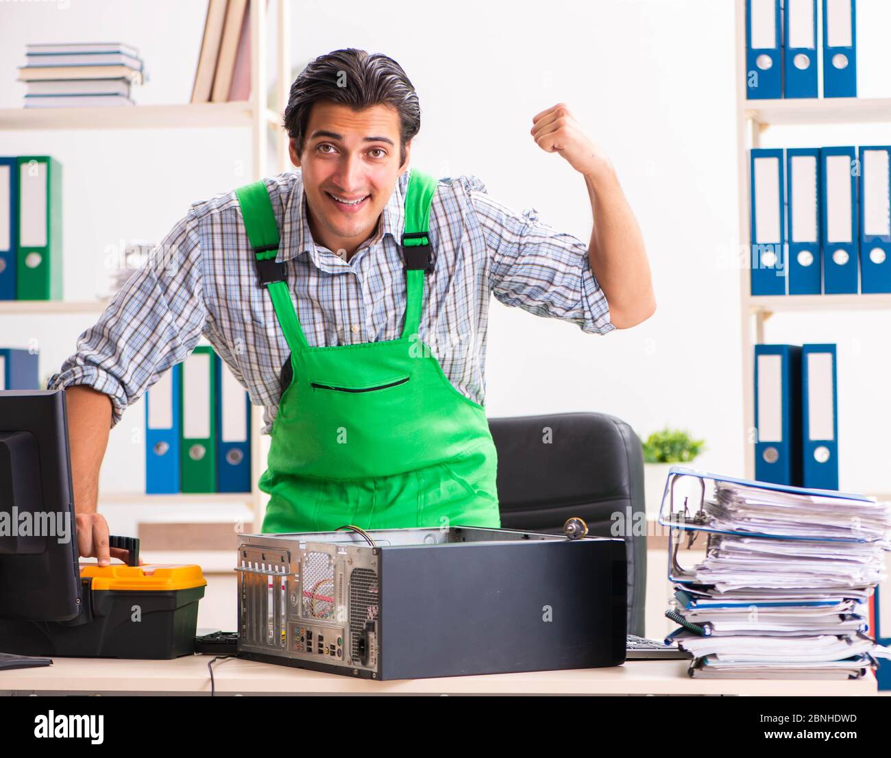 The young engineer repairing broken computer at the office Stock Photo ...