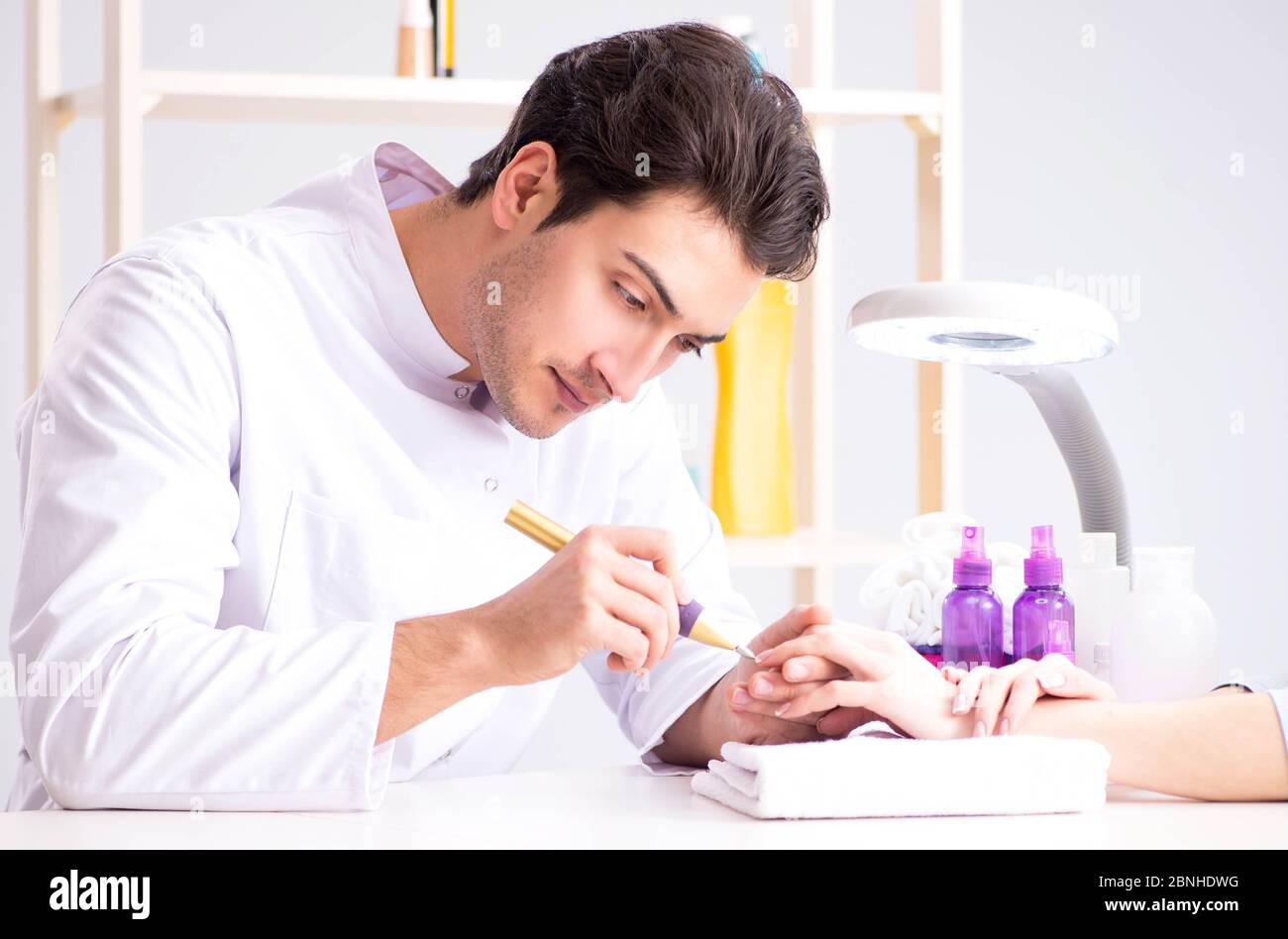 The hands during manicure care session Stock Photo - Alamy