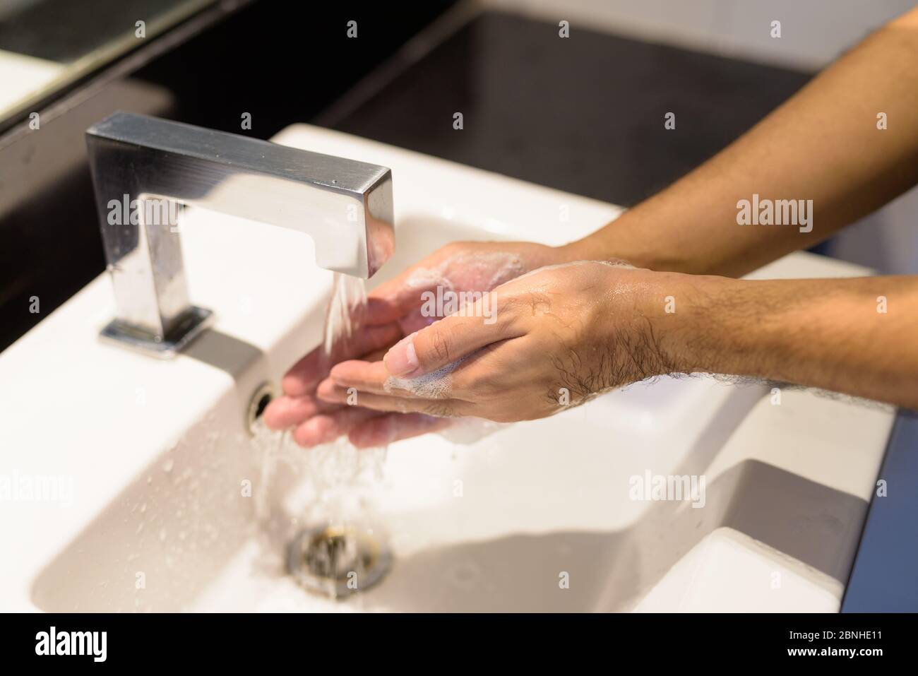 Hands of young man being washed and cleaned properly to prevent the ...